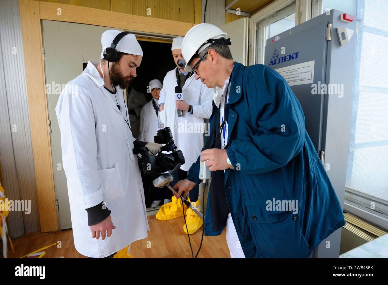 Man technician measuring levels of radiation on journalist s equipment ...