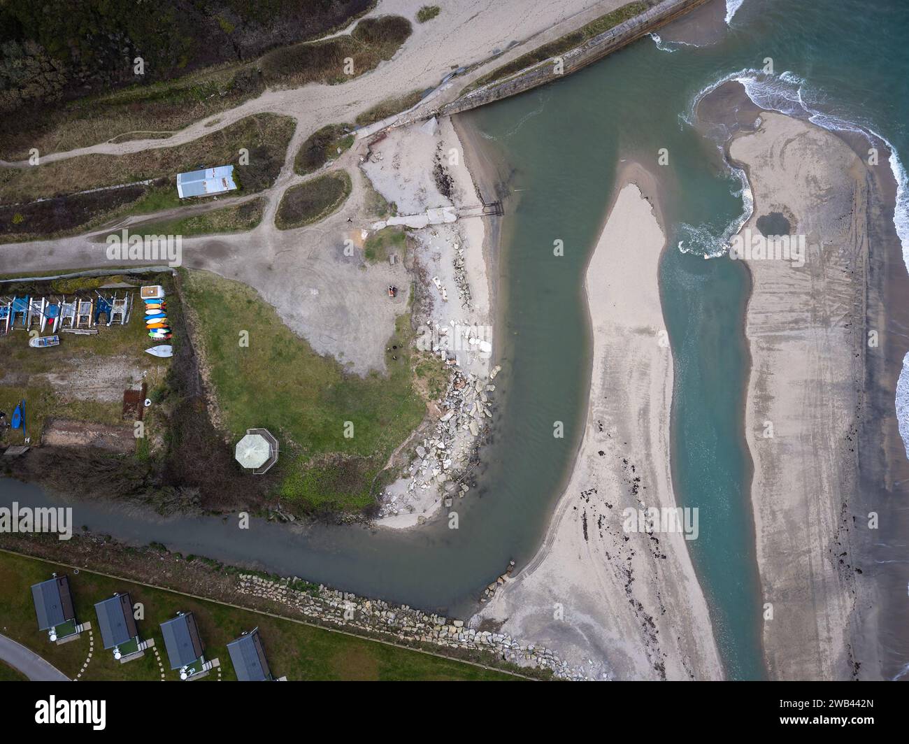 River outlet to the sea at Pentewan Cornwall with sand banks protecting ...