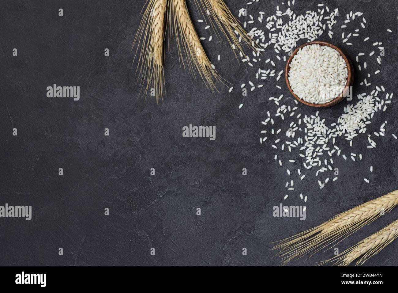 Glutinous rice in wooden bowl. Sprigs of cereals and sprinkled rice on ...