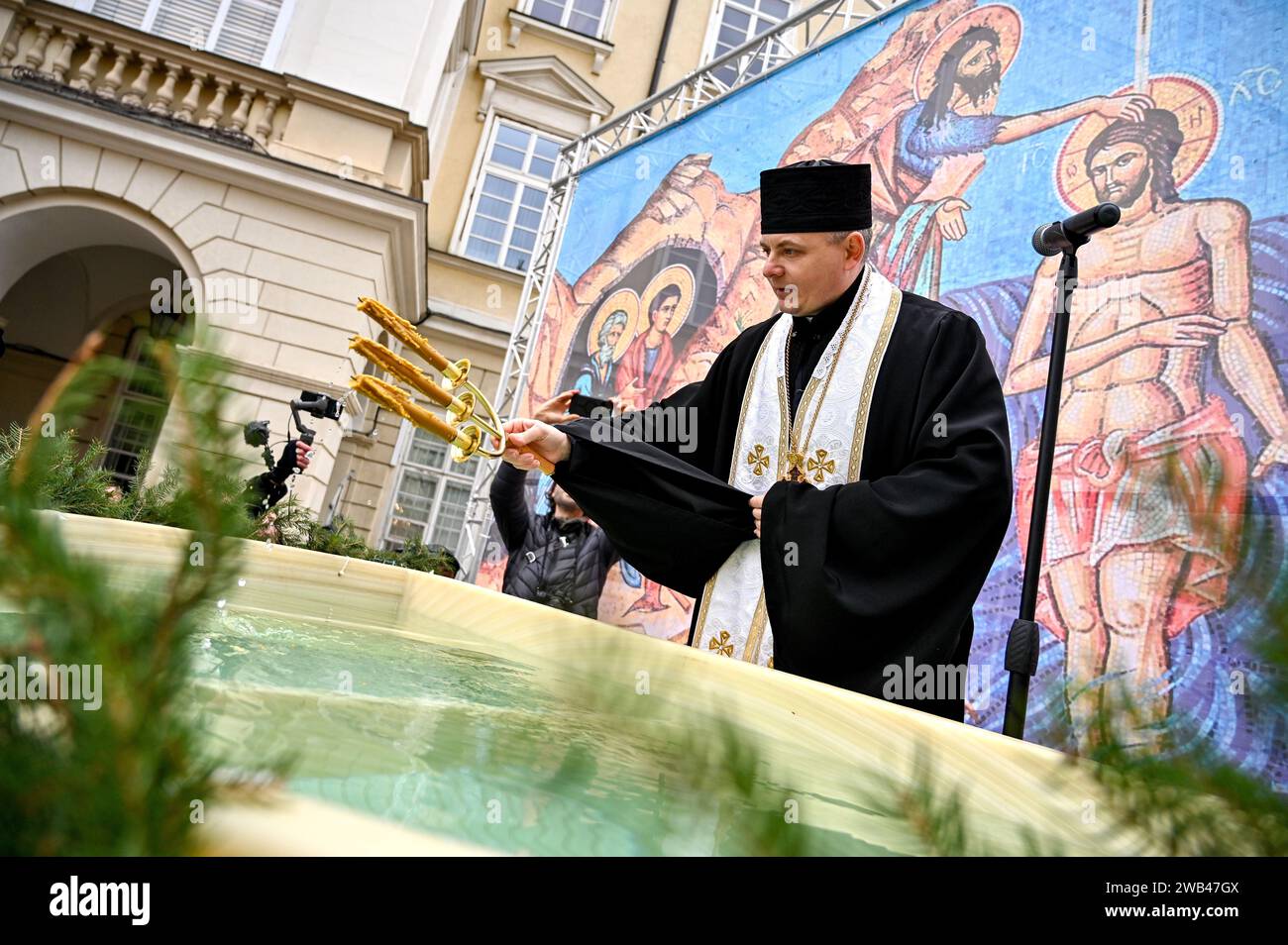 Non Exclusive: LVIV, UKRAINE - JANUARY 6, 2024 - A priest dips a ...