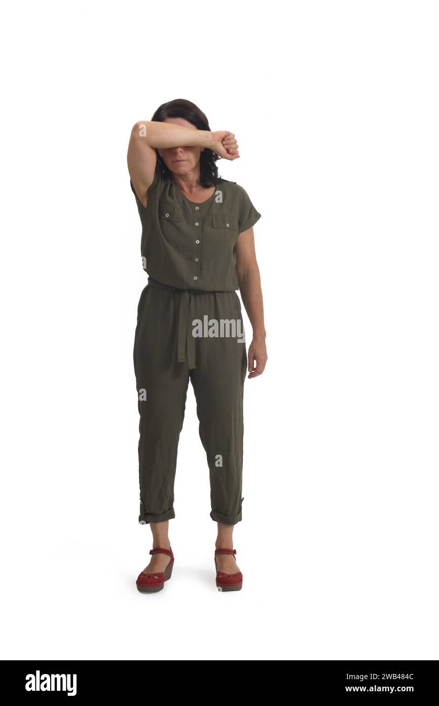 front view of a woman covering her face with her arm on white ...