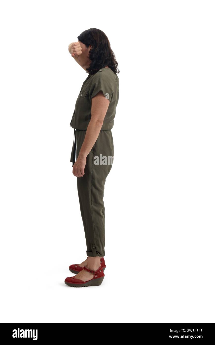 side view of a woman covering her face with her arm on white background ...