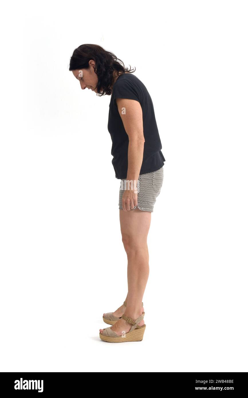 side view of a woman crouching and looking at the ground on white ...