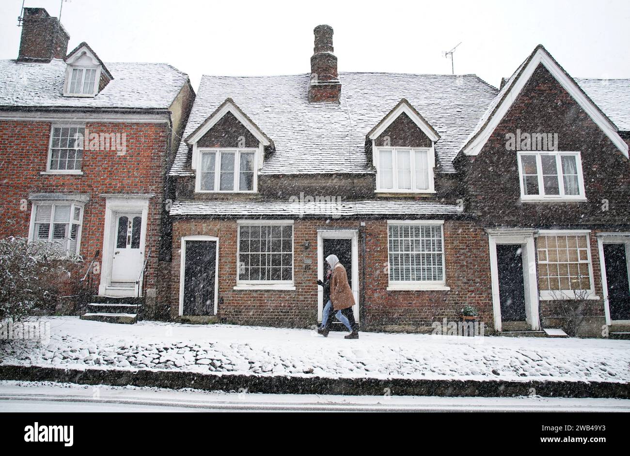 People walking through a snow flurry in Lenham, Kent. Sleet and snow ...