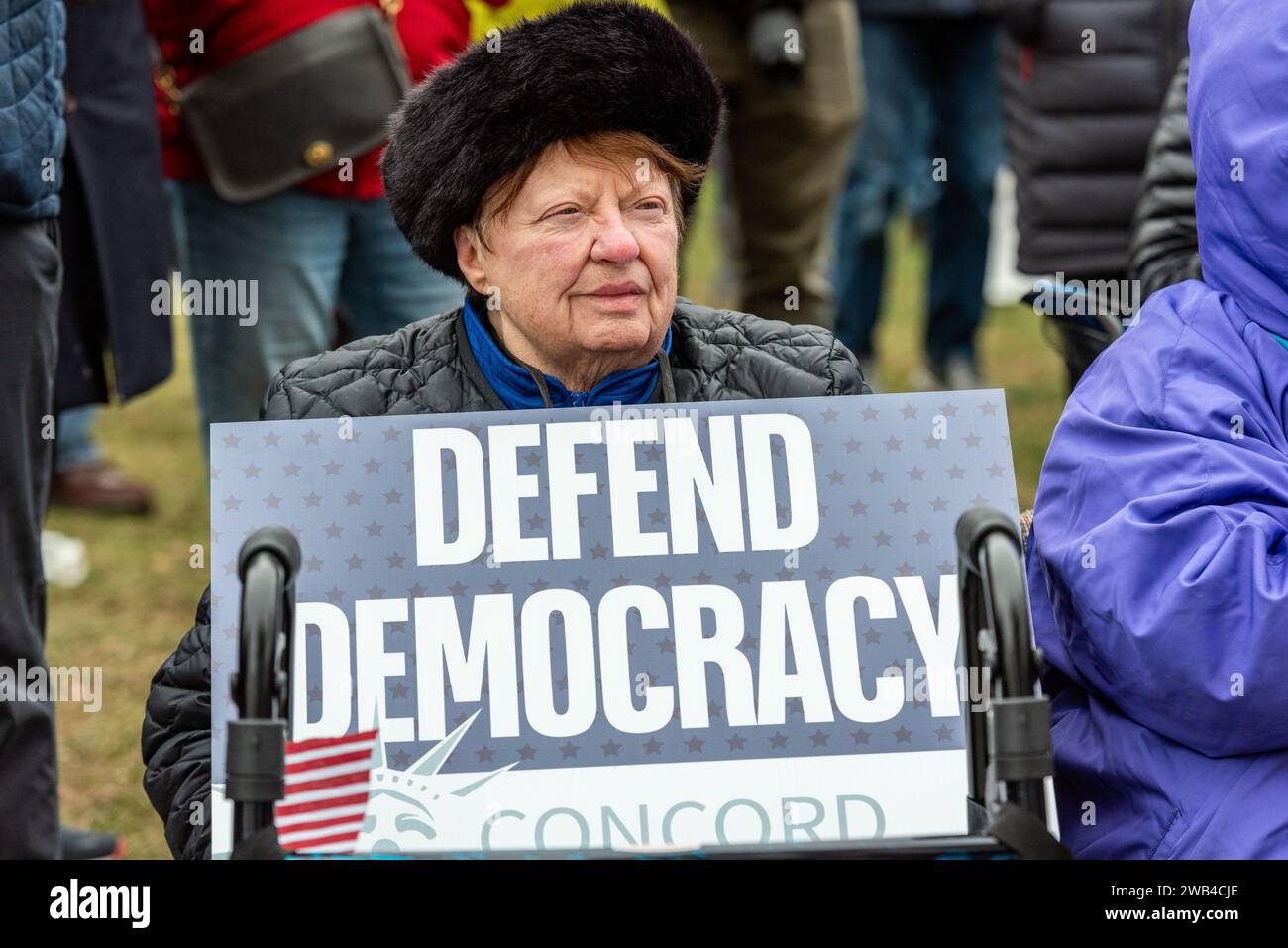 Woman holding Defend Democracy sign at rally on the third anniversary ...