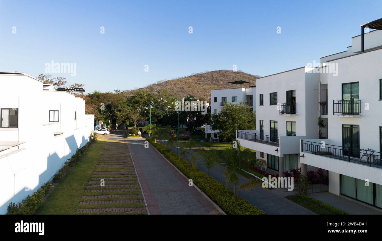 Sidewalk and green areas surrounded by white houses aerial view of ...