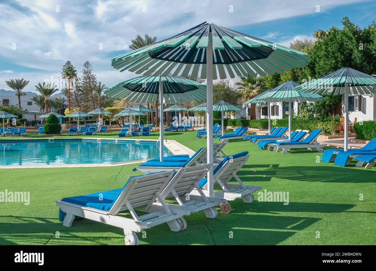 Beautiful swimming pool in tropical resort with palms. Swimming pool ...