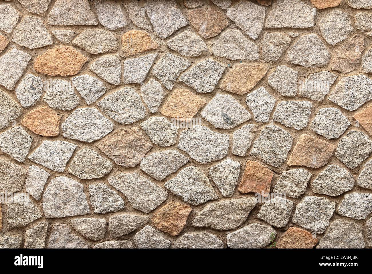 yellow beige natural stone wall of different sized stones, traditional ...