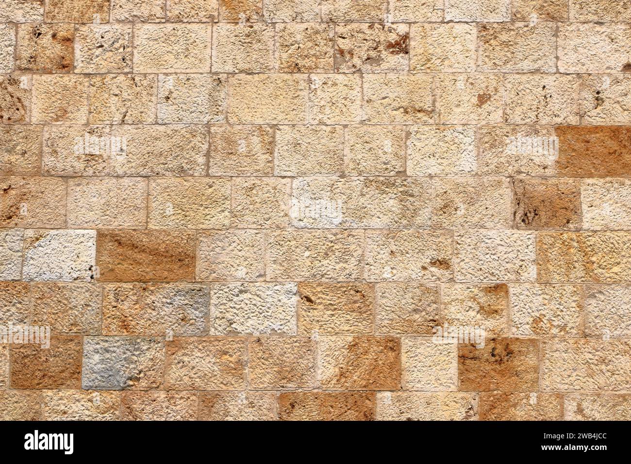 yellow beige natural stone wall of different sized stones, traditional ...