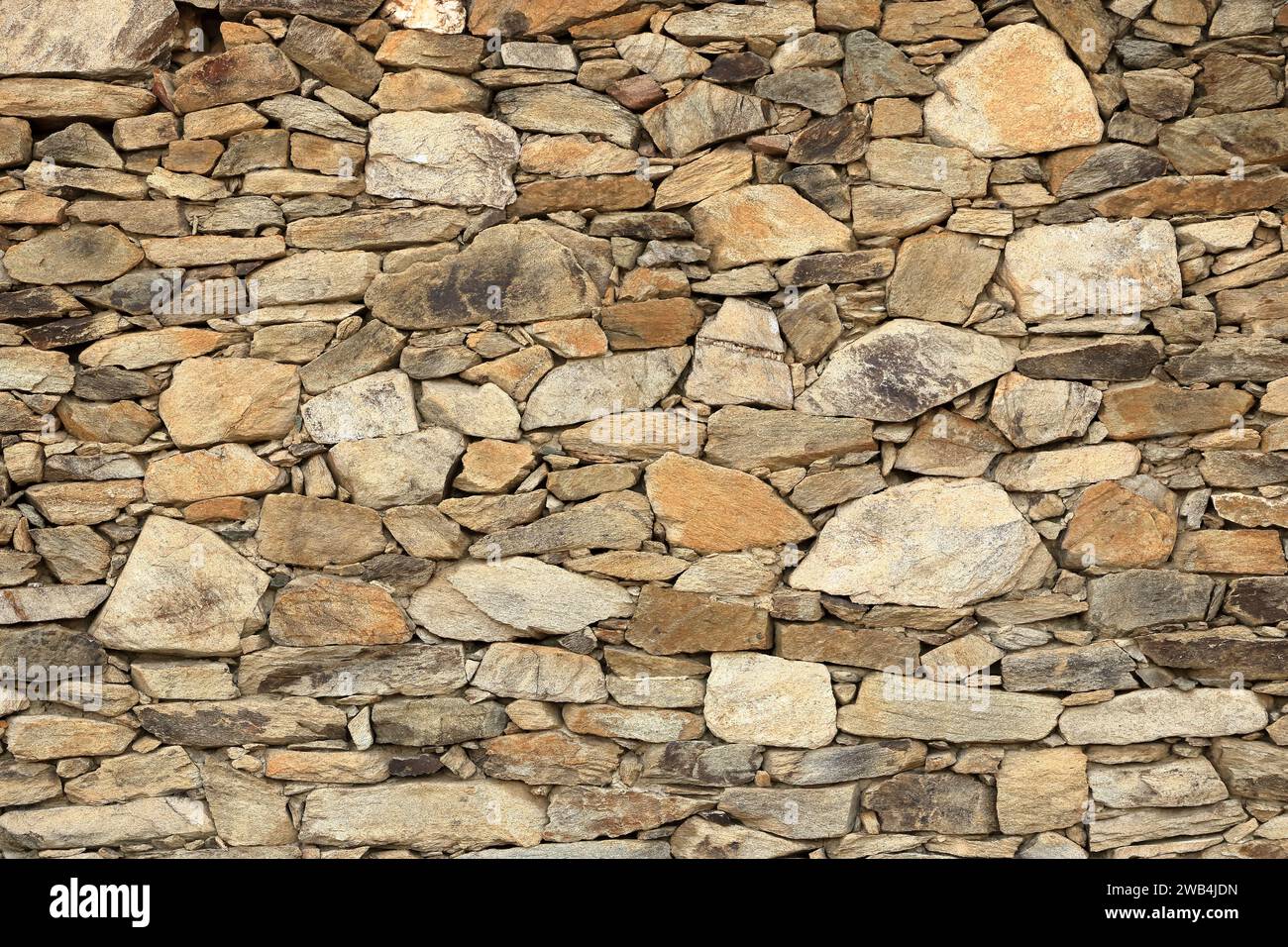 yellow beige natural stone wall of different sized stones, traditional ...