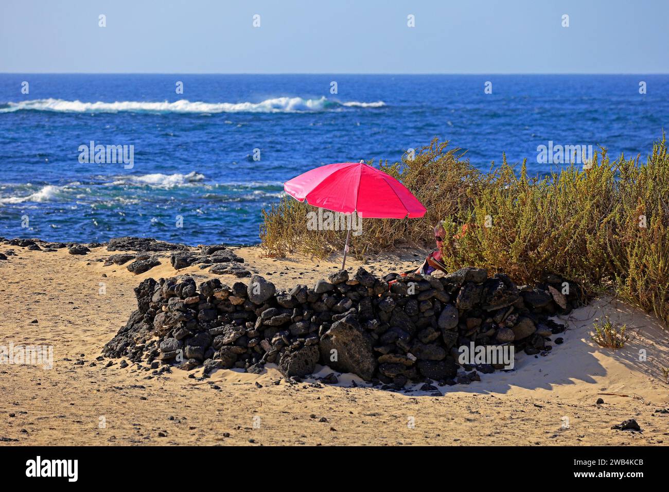 Beach scene with sheltered lagos stone features and umbrellas,, El ...