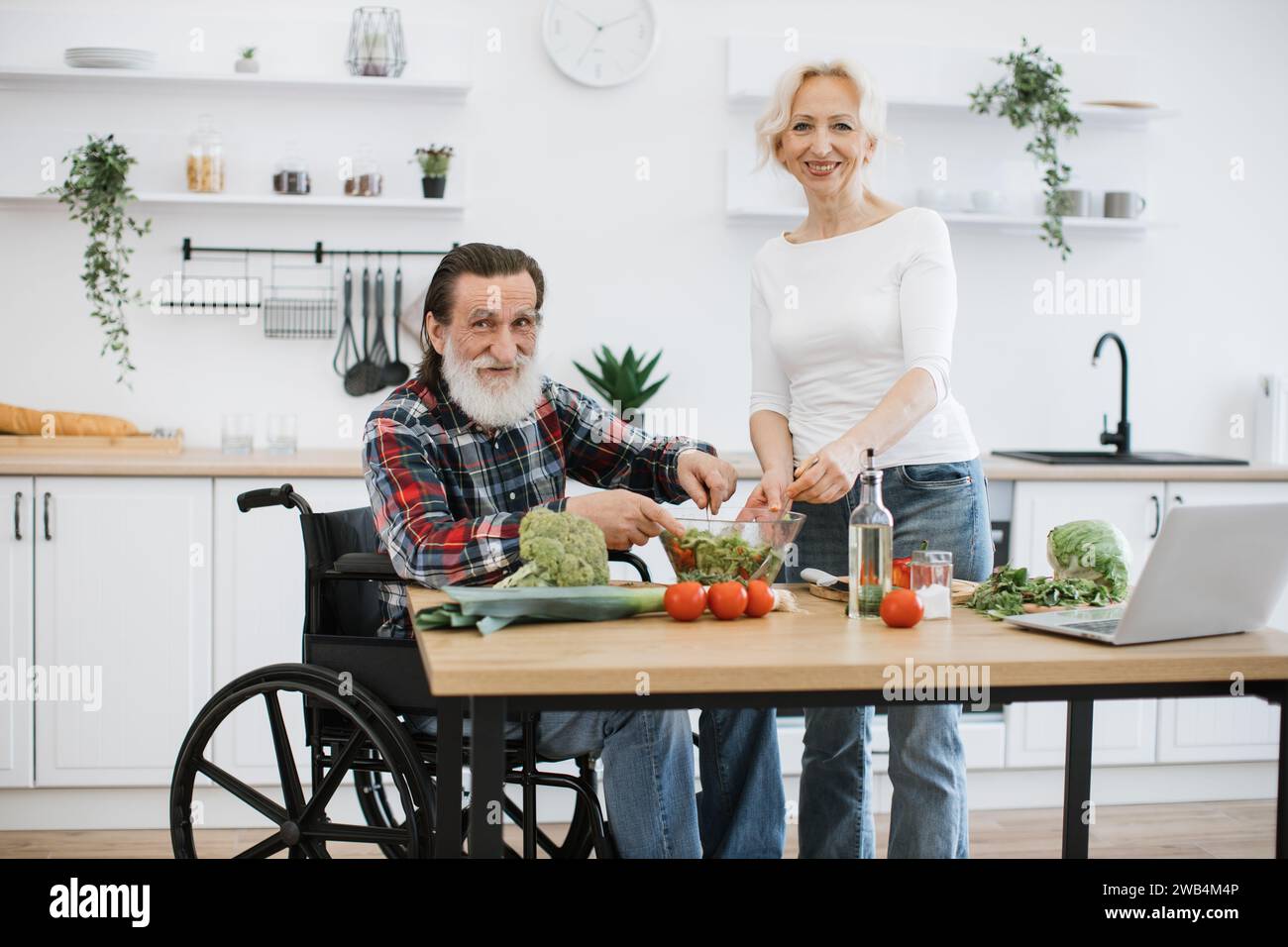 Old couple with disability spends time cooking breakfast in modern ...
