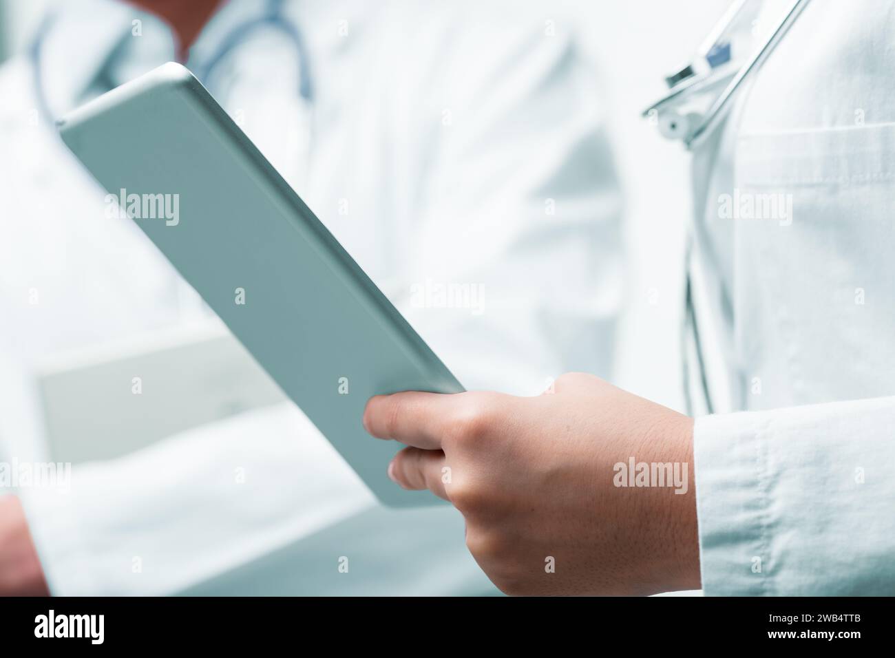 medical practitioner's hands on a tablet illustrate the integration of ...