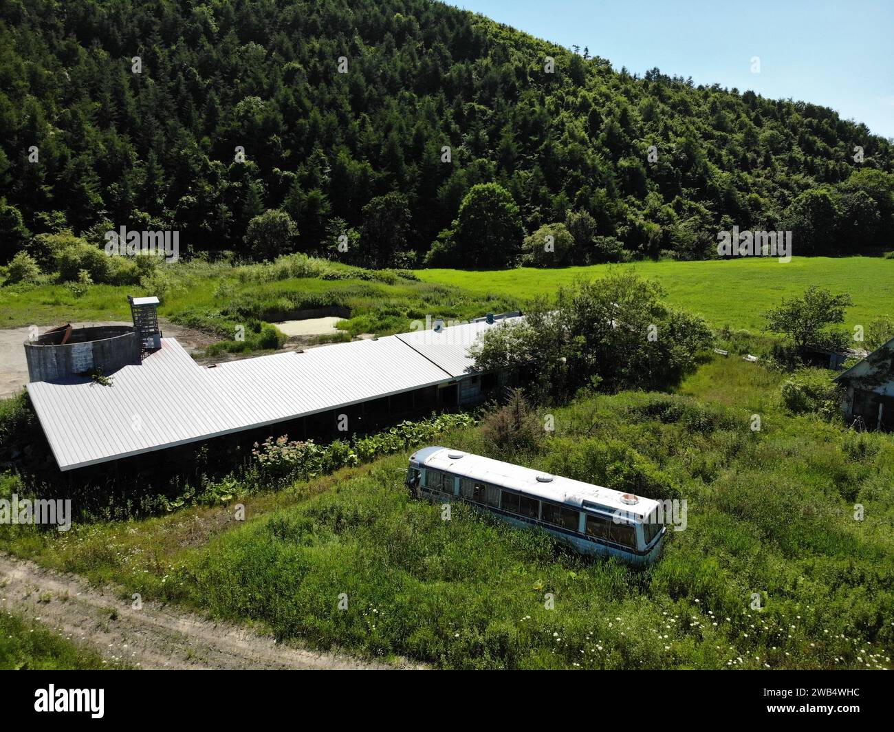 abandoned farm and bus, that are reclaimed by nature Stock Photo - Alamy