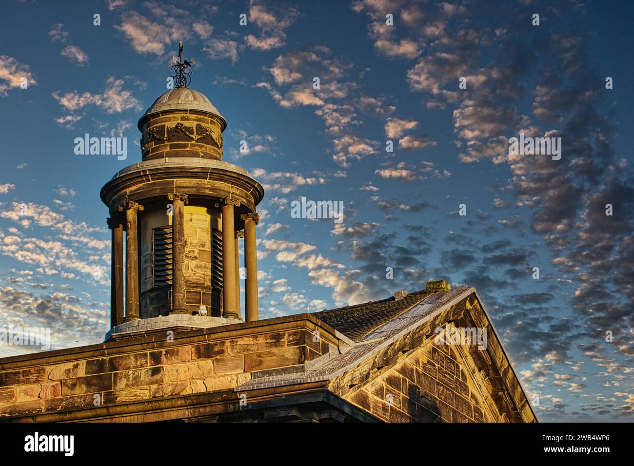 Historic stone building with a dome under a blue sky with scattered ...