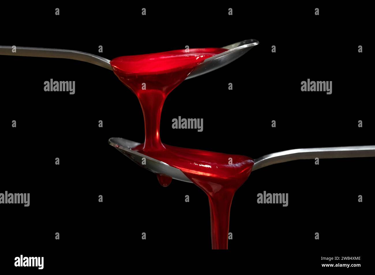 Fruit red jam dripping from spoon on black background Stock Photo - Alamy