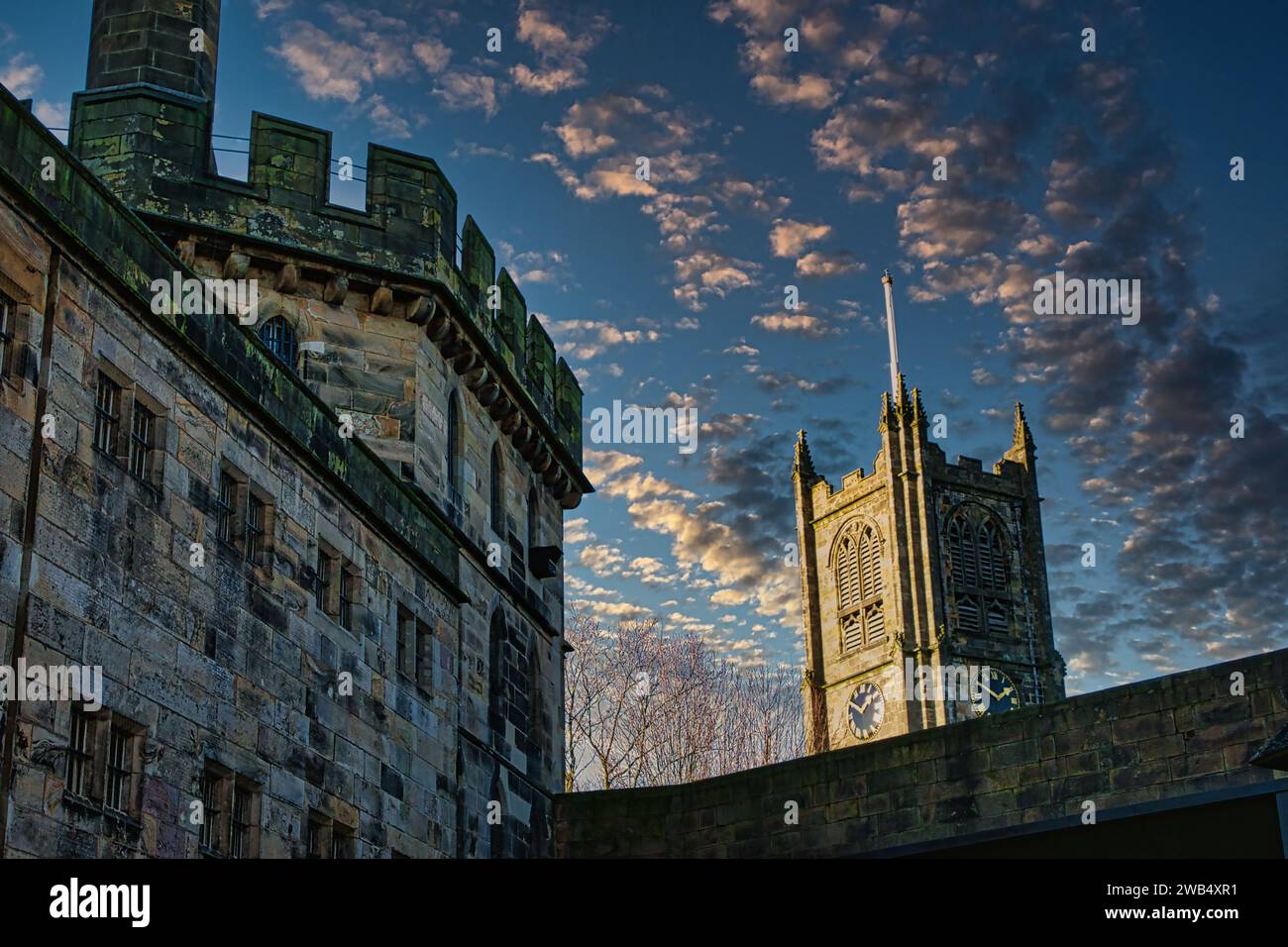 Historic stone buildings with towers against a dramatic sky at dusk in ...