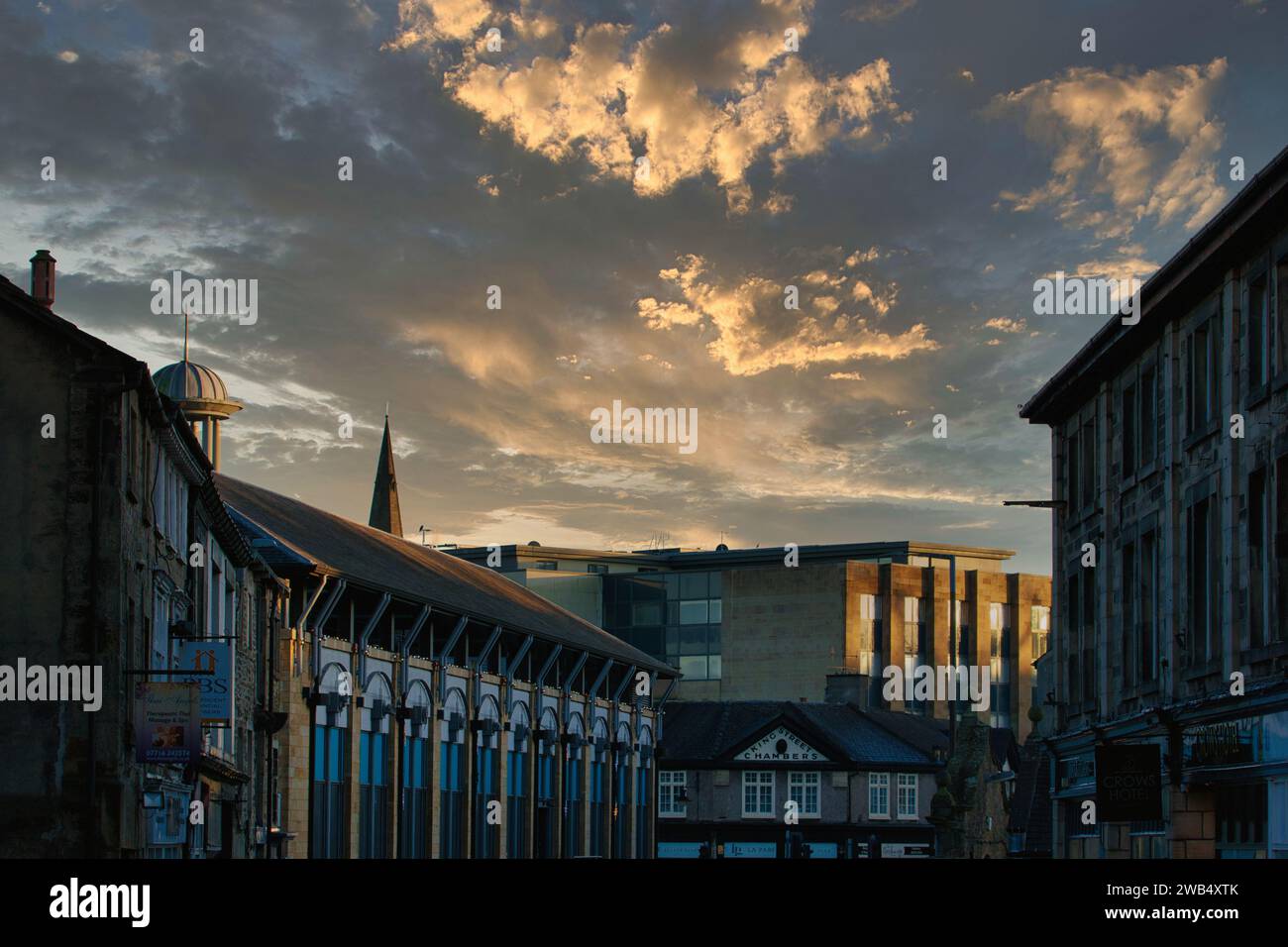 Dramatic sunset over a quaint town street with historic buildings and a ...