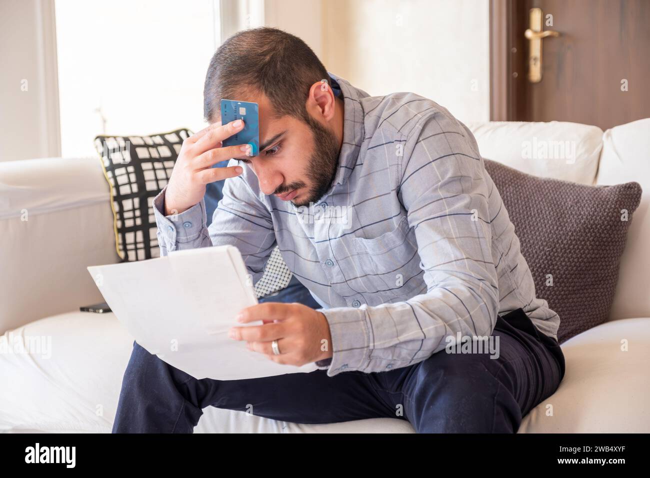 male holding bank card while feeling stressed due to financial issue ...