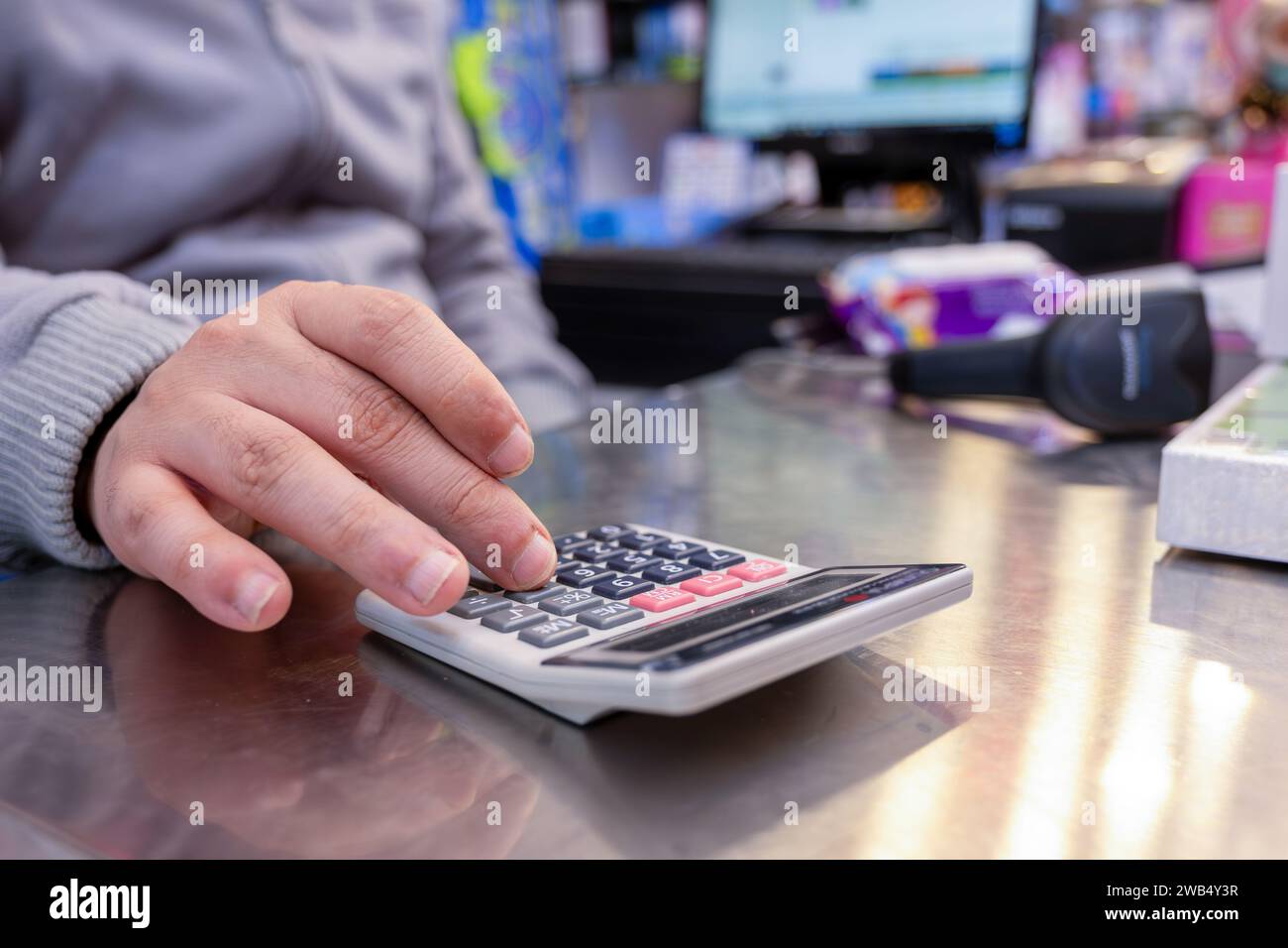 Cashier hands while calculating with barcode scanner and cashier drawer ...