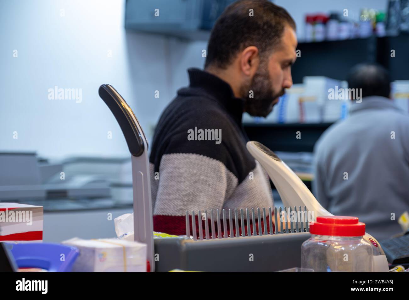 Book shop owner with printers in the background for printing services ...