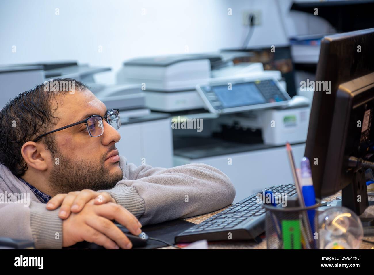 Book shop owner with printers in the background for printing services ...