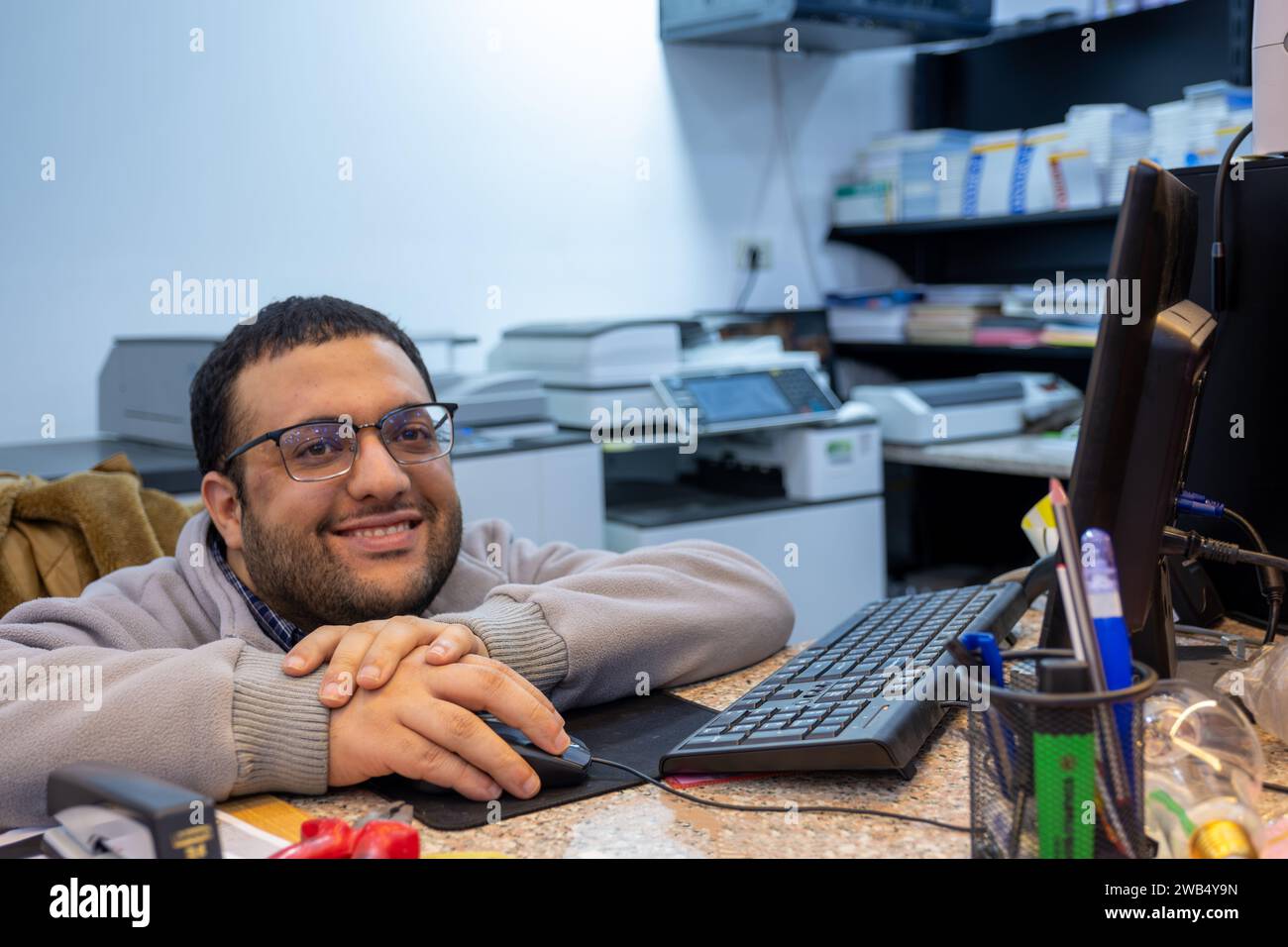 Book shop owner with printers in the background for printing services ...