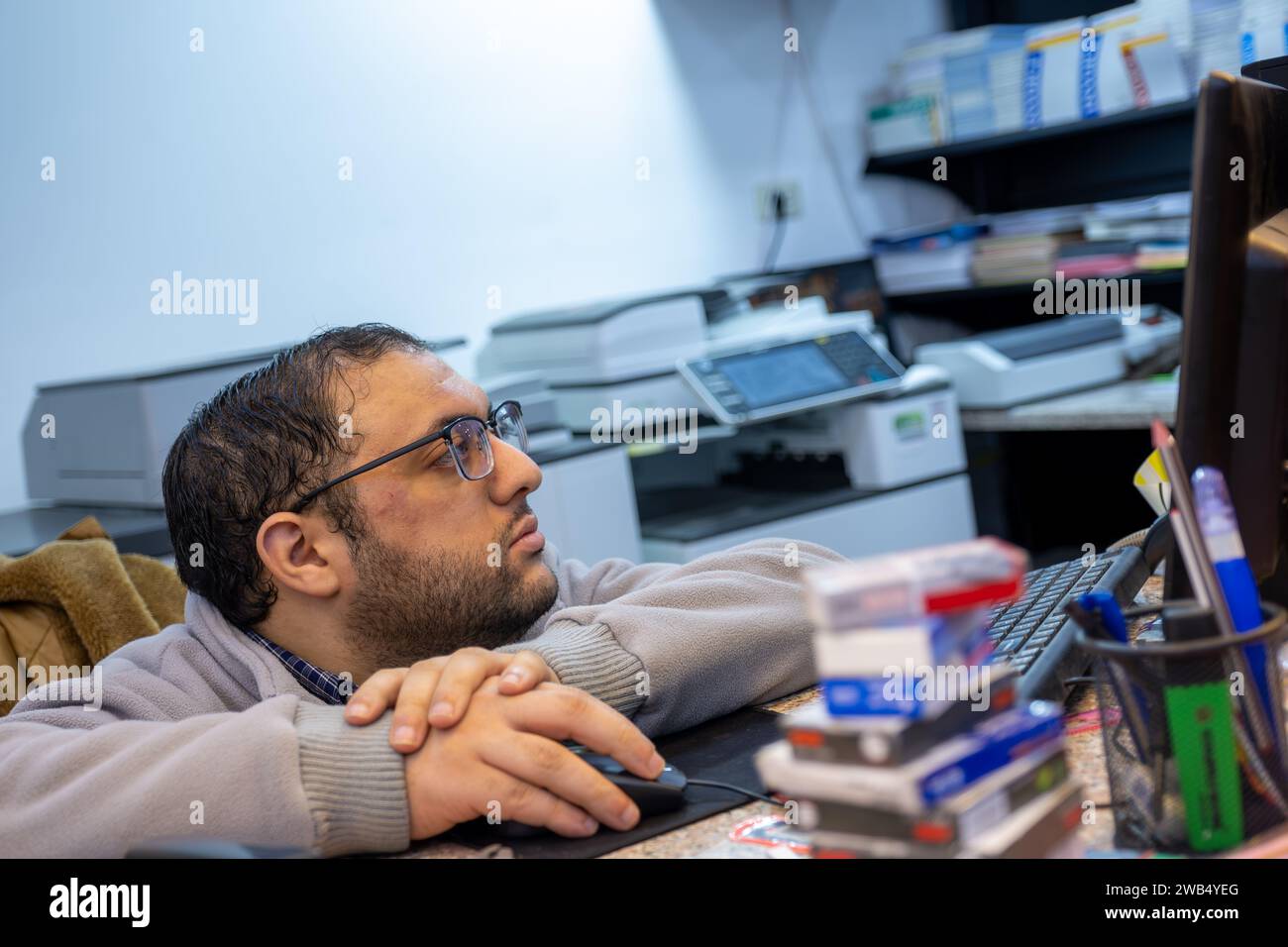 Book shop owner with printers in the background for printing services ...