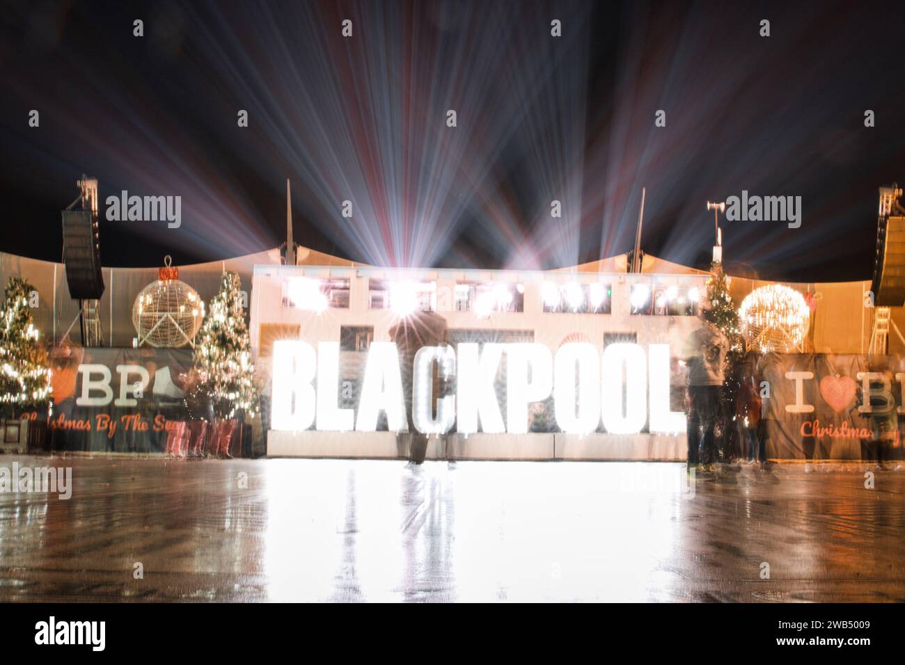 Illuminated Blackpool sign with light rays at night, reflecting on wet ...