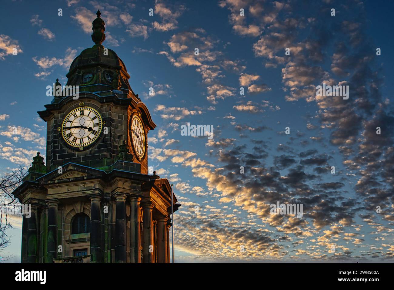 Historic clock tower silhouette against a dramatic sunset sky with ...