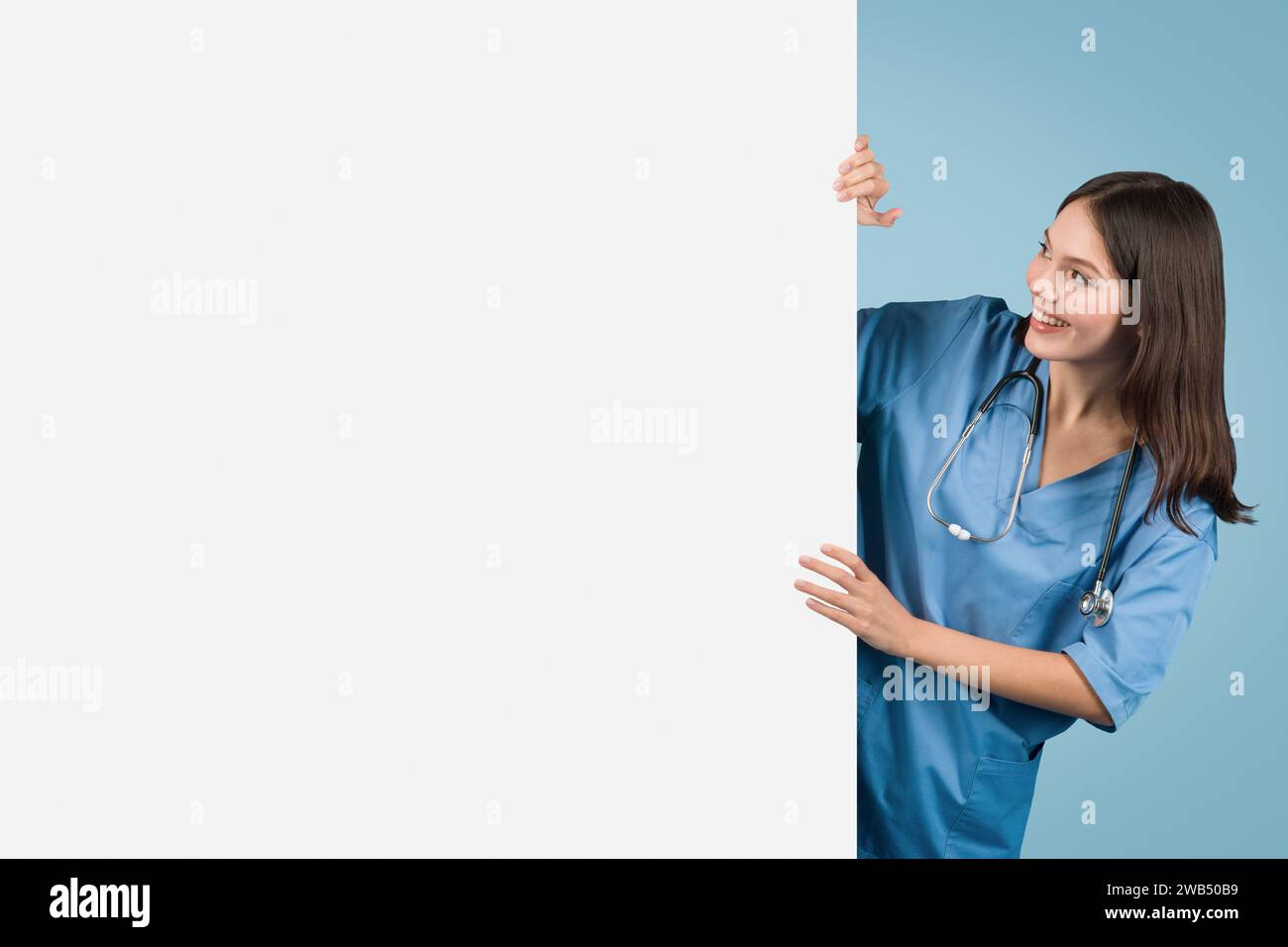 Nurse in blue showing a large sign, ideal for custom content Stock ...