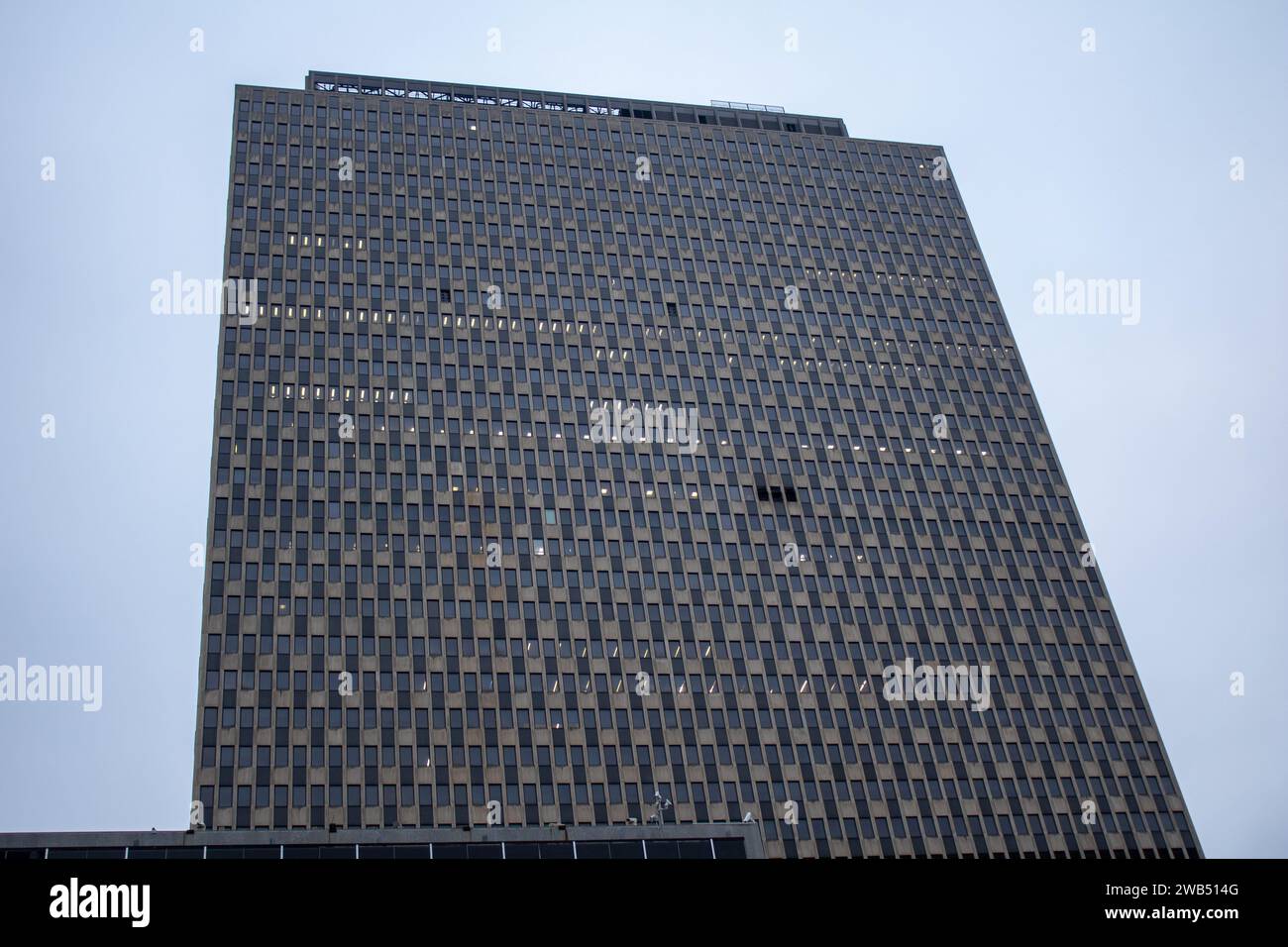 A tall modern skyscraper with multiple windows illuminated by the ...