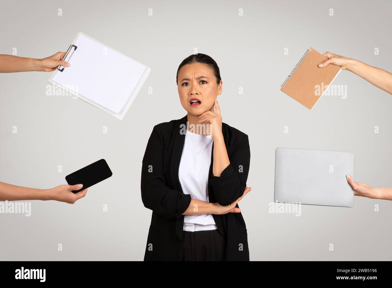 Confused pensive young asian lady in suit think, hands give her laptop ...