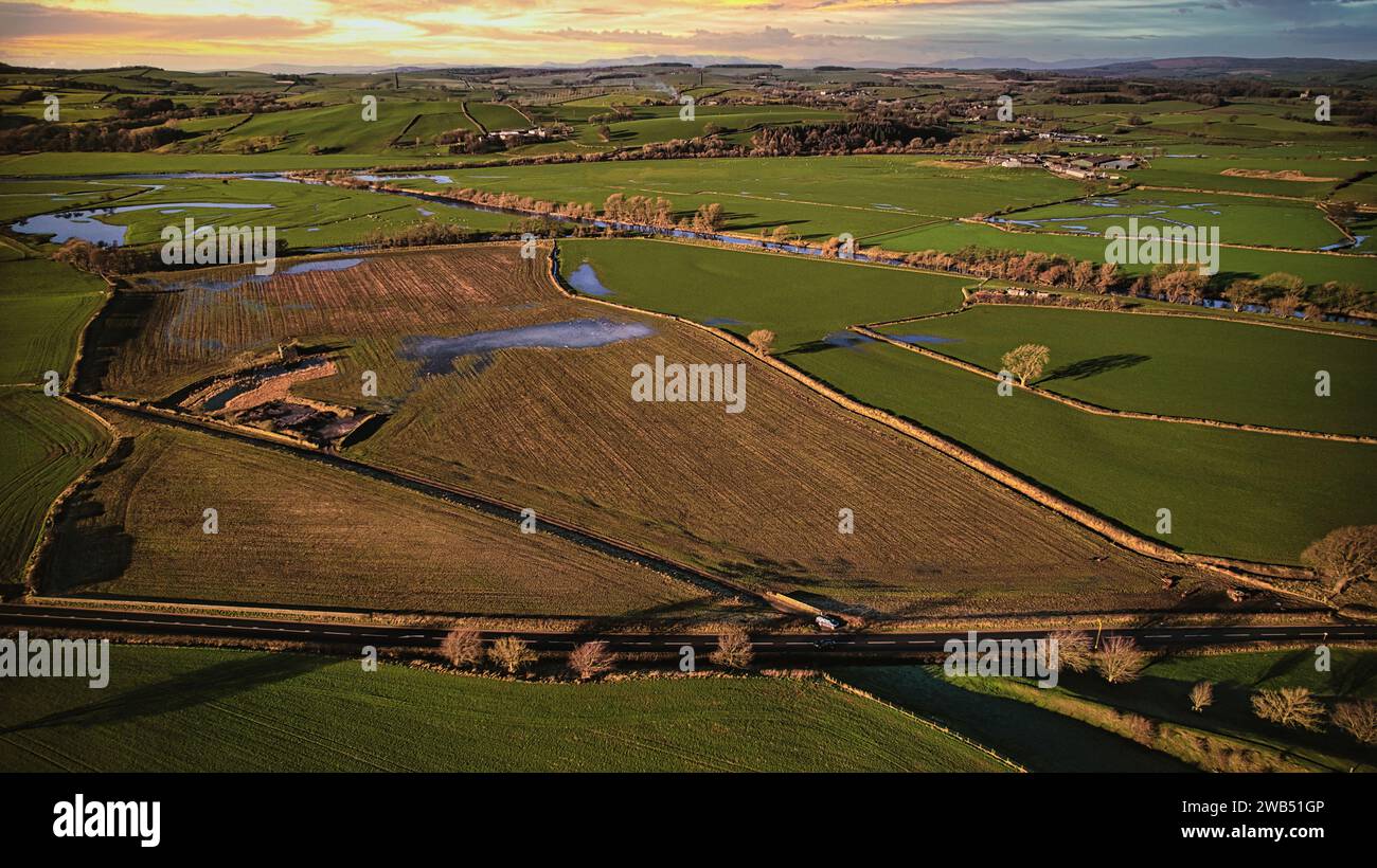 Aerial view of a serene rural landscape with fields, a winding river ...
