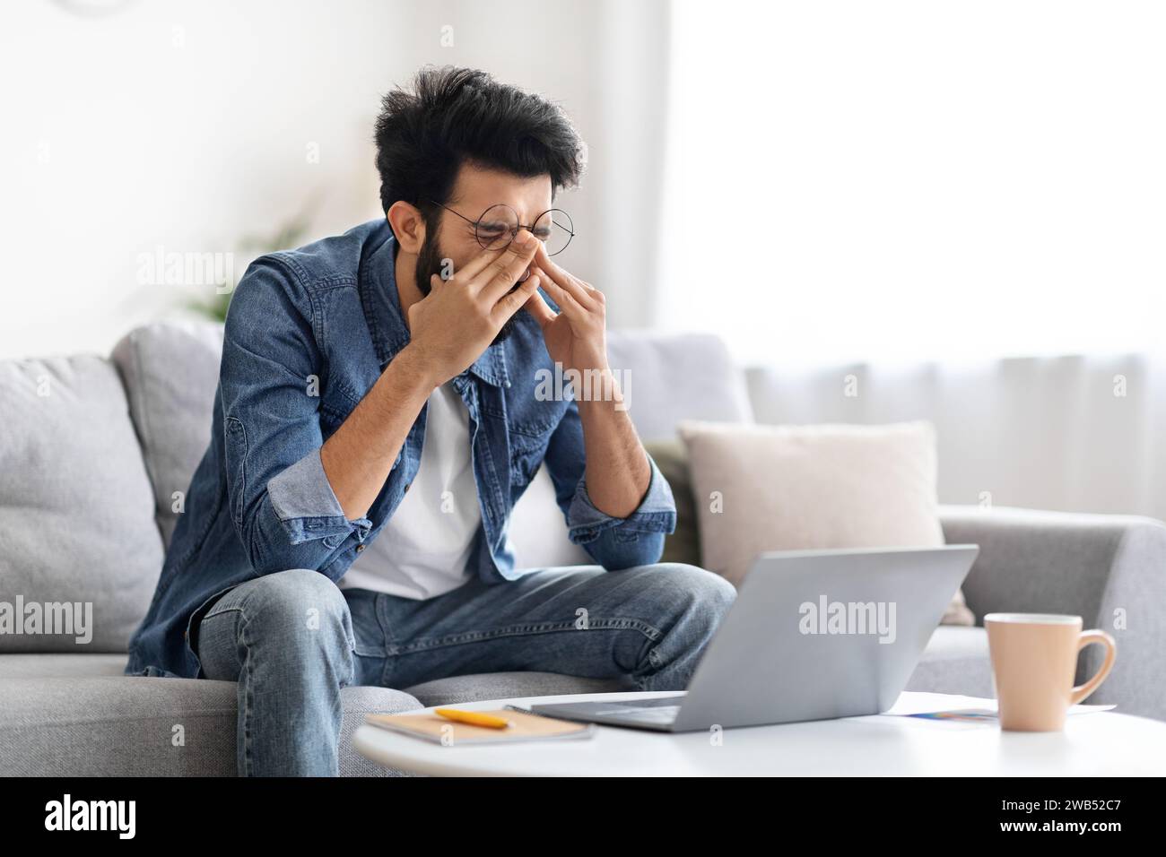 Tired indian man rubbing eyes, suffering fatigue while working on ...