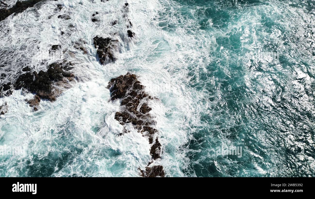 An aerial view of a tranquil beach scene featuring a body of blue water ...