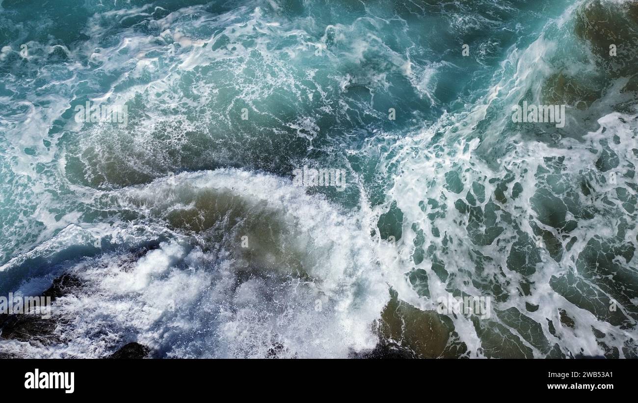 An aerial view of a tranquil beach scene featuring a body of blue water ...