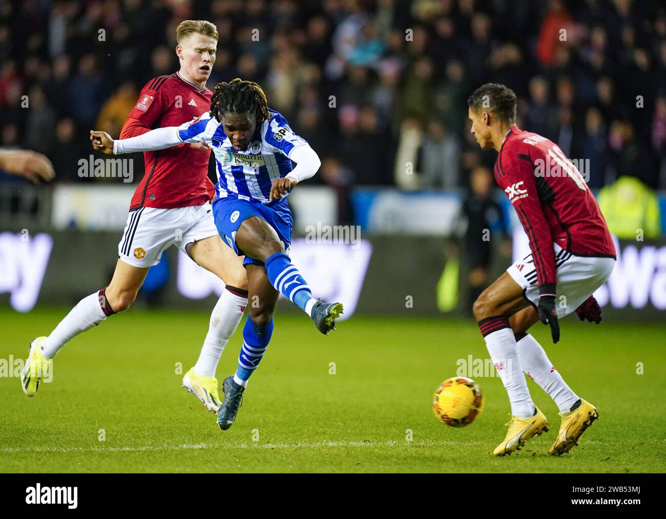 Wigan Athletic's Babajide Adeeko shot is blocked by Manchester United's ...