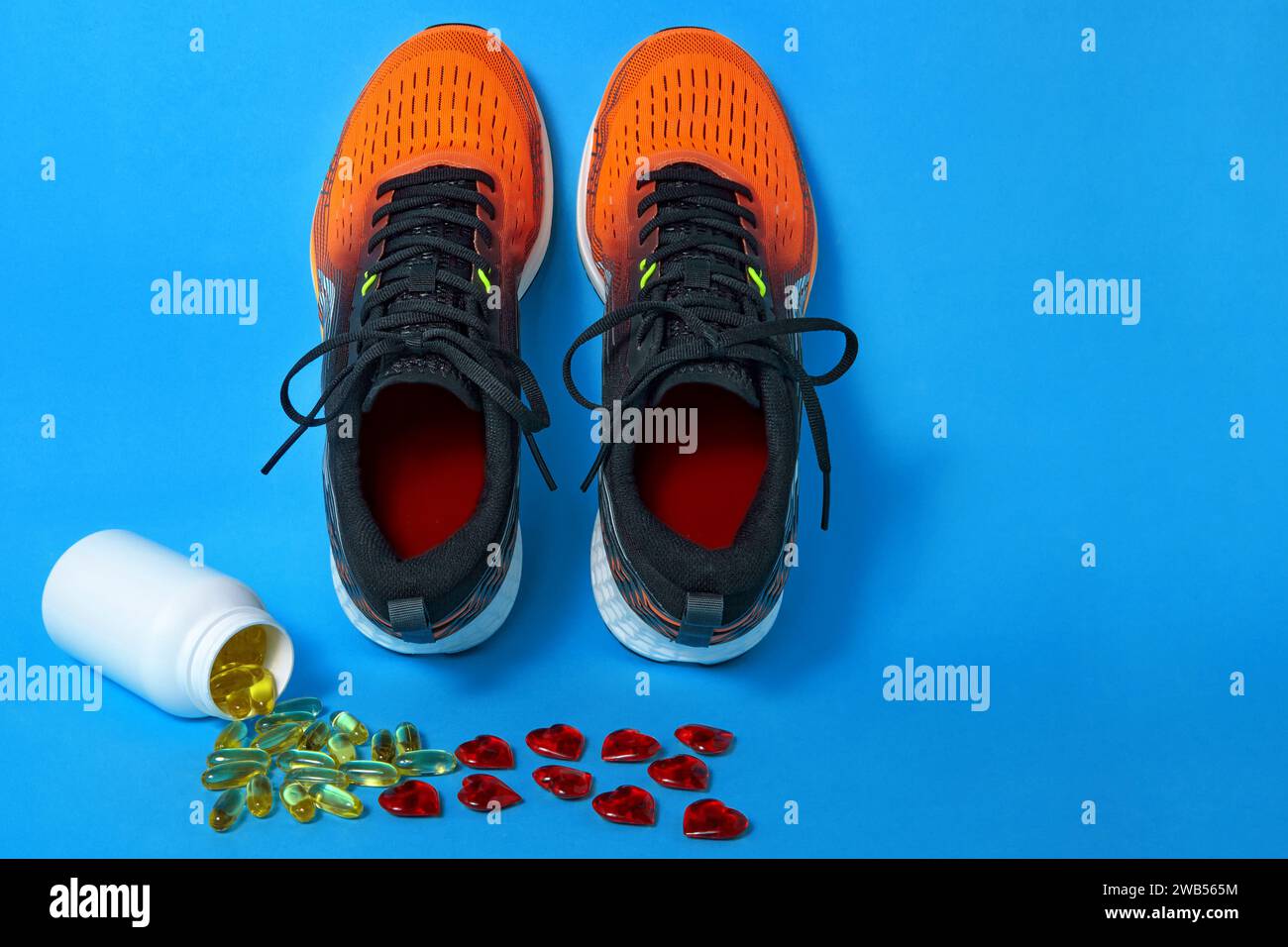 Orange running shoes and yellow unsaturated fatty acid capsules with ...