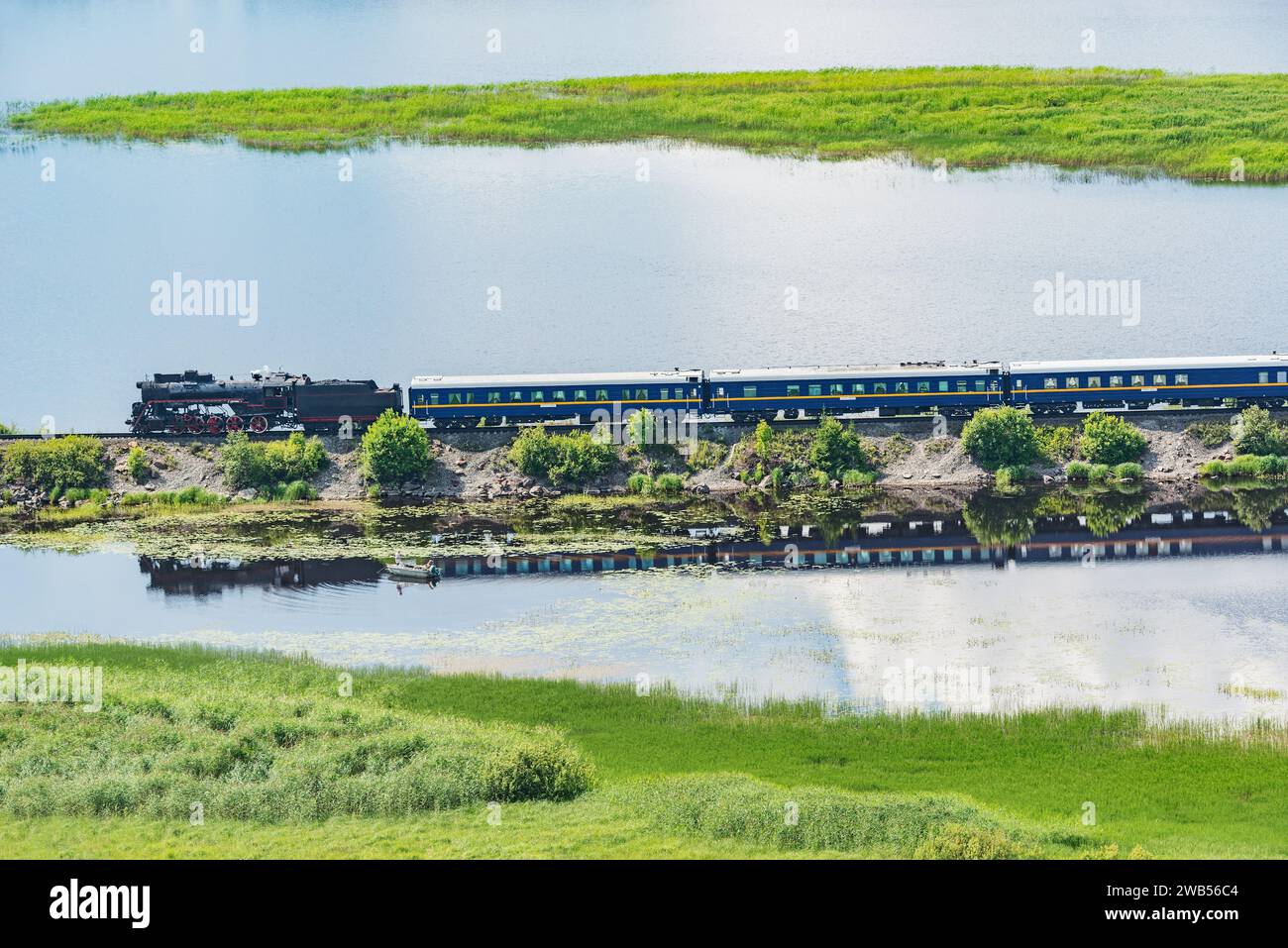 Retro steam train moves along the lake Stock Photo - Alamy