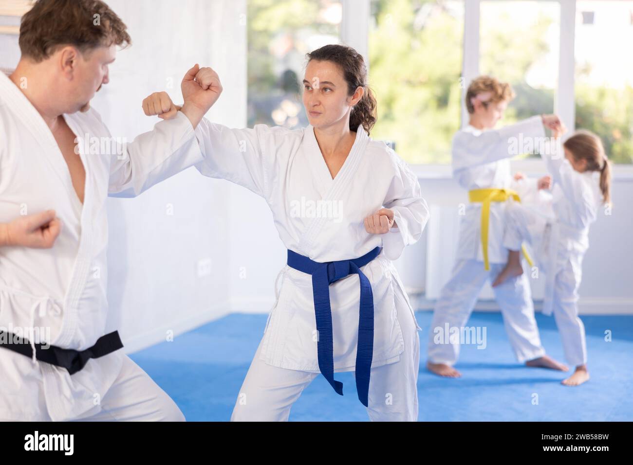 Family with child train to perform defensive karate installations and ...