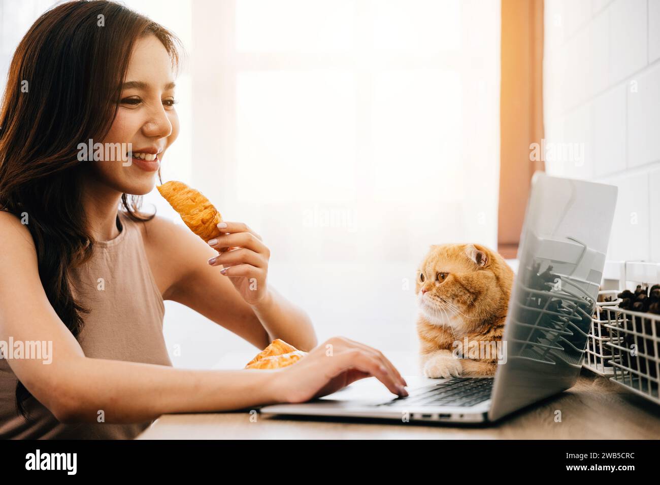 In this heartwarming home office scene, a woman balances her work on a ...