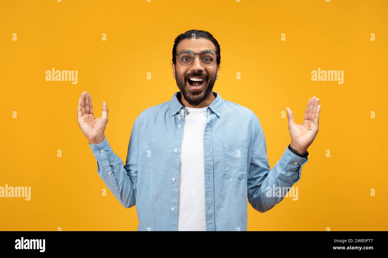 Exuberant man with a beard and glasses, arms raised in a welcoming ...