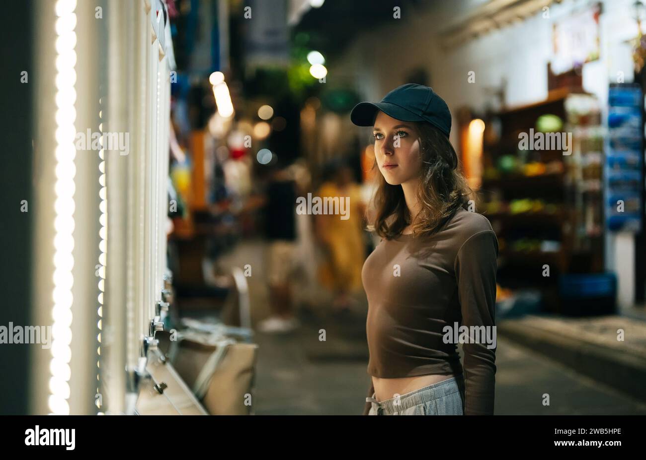 Teenage girl looks at store showcase at evening Stock Photo - Alamy