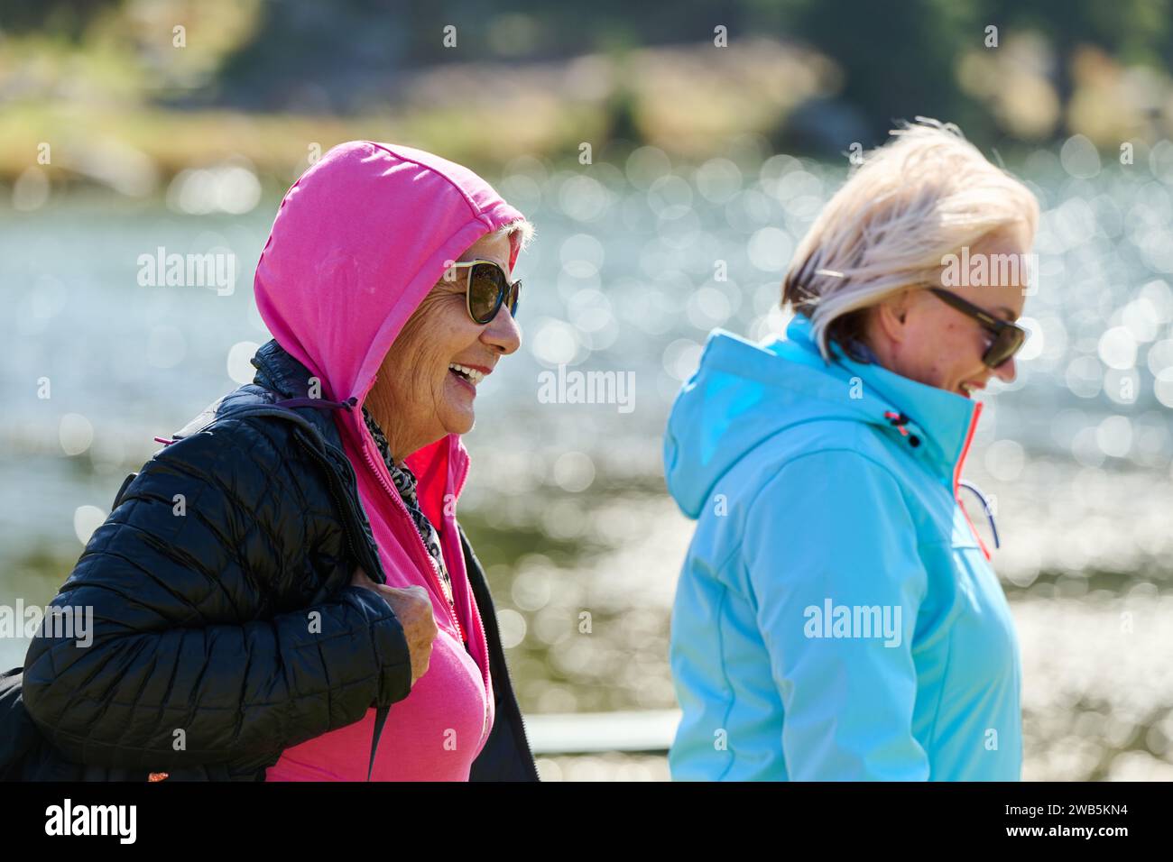 Senior friends enjoys a leisurely stroll in nature, immersed in joyous ...