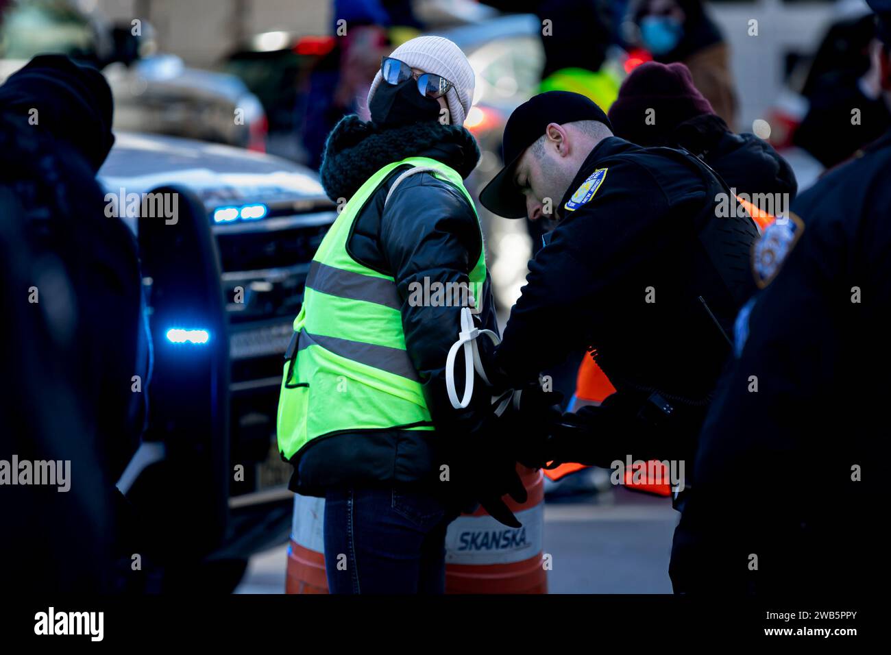 NEW YORK, NEW YORK - JANUARY 8: A police officer places handcuffs onto ...