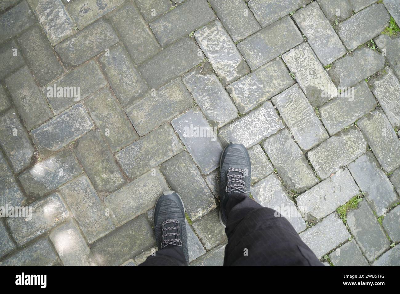 Barefoot man walking on block paving road Stock Photo - Alamy