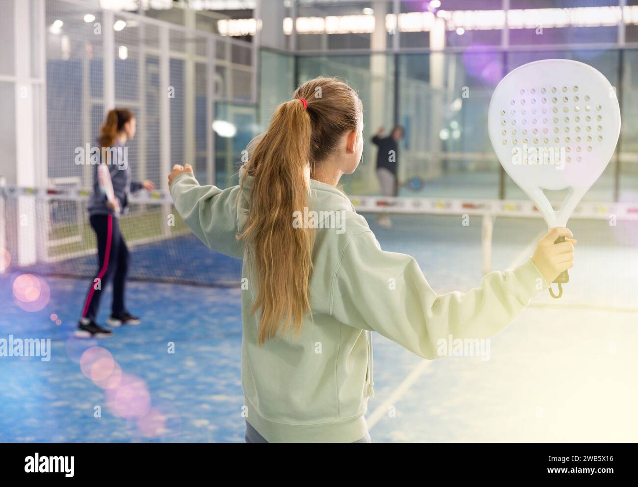 Teenage girl playing padel in court Stock Photo - Alamy