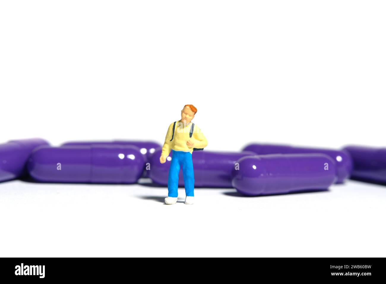 Miniature people toy figure photography. A boy student standing in ...