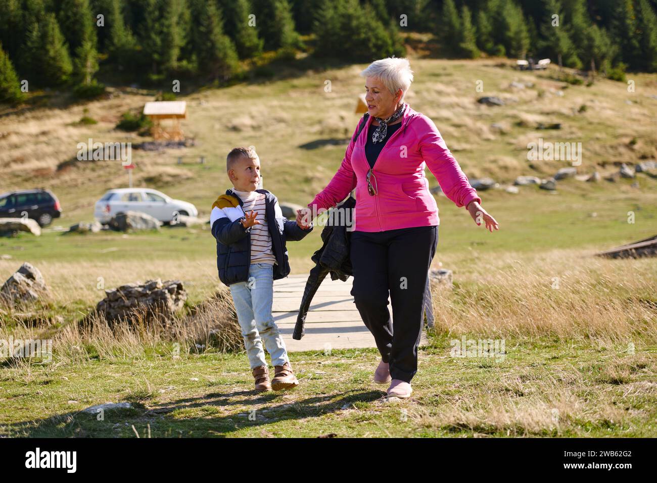 Elderly grandmother and her grandchild share a leisurely stroll through ...